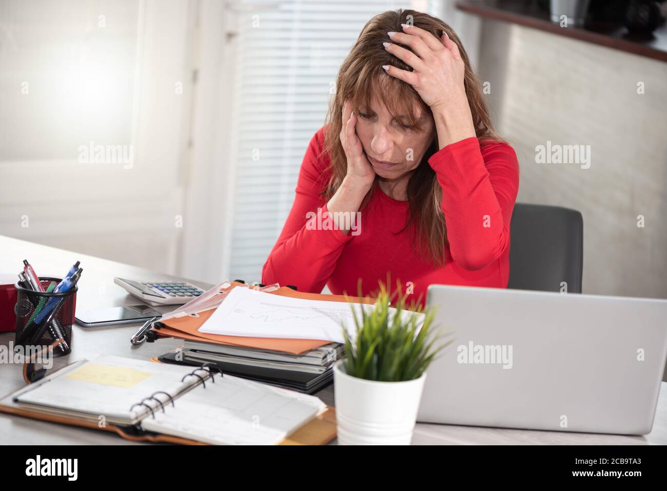 Overworked and exhausted businesswoman sitting at workplace Stock Photo ...