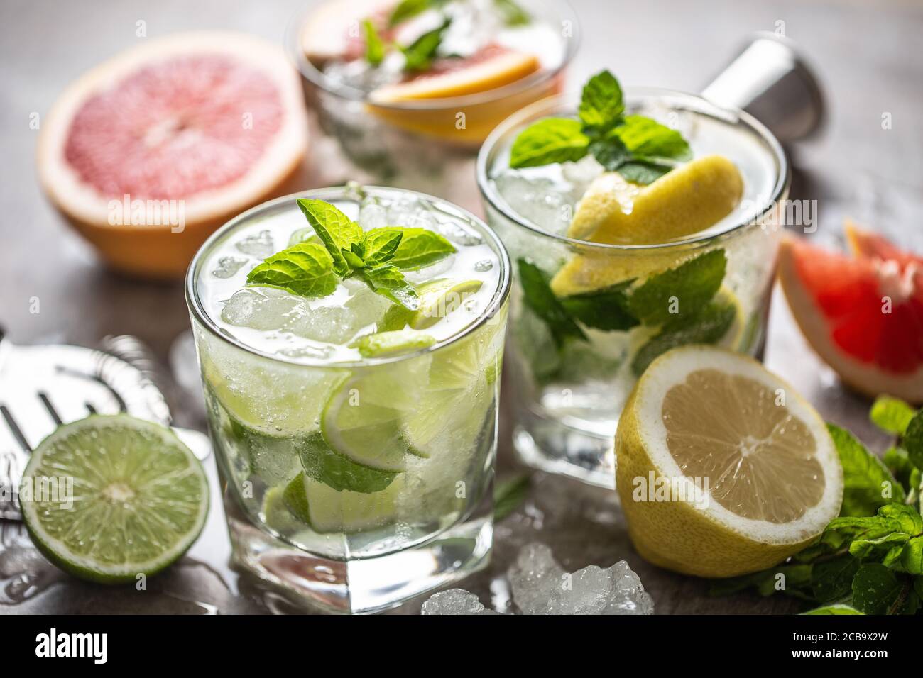 Three colorful gin tonic cocktails in whiskey glasses on bar counter in ...