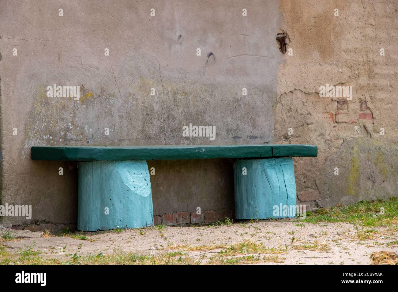 Beautiful turquoise simple wooden bench near an old building wall Stock ...