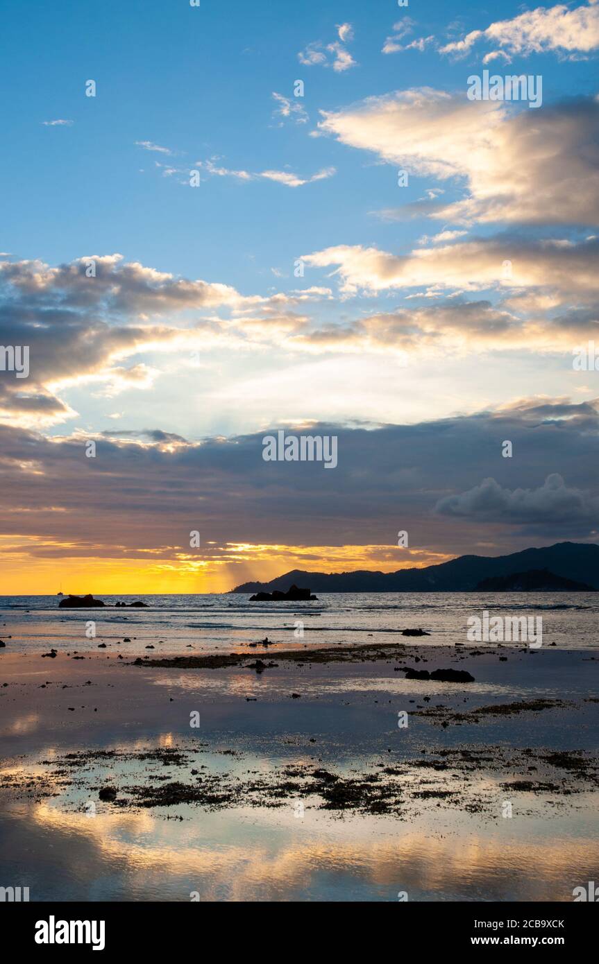 Beautiful tropical sunset with vibrant warm colours over the water with ...