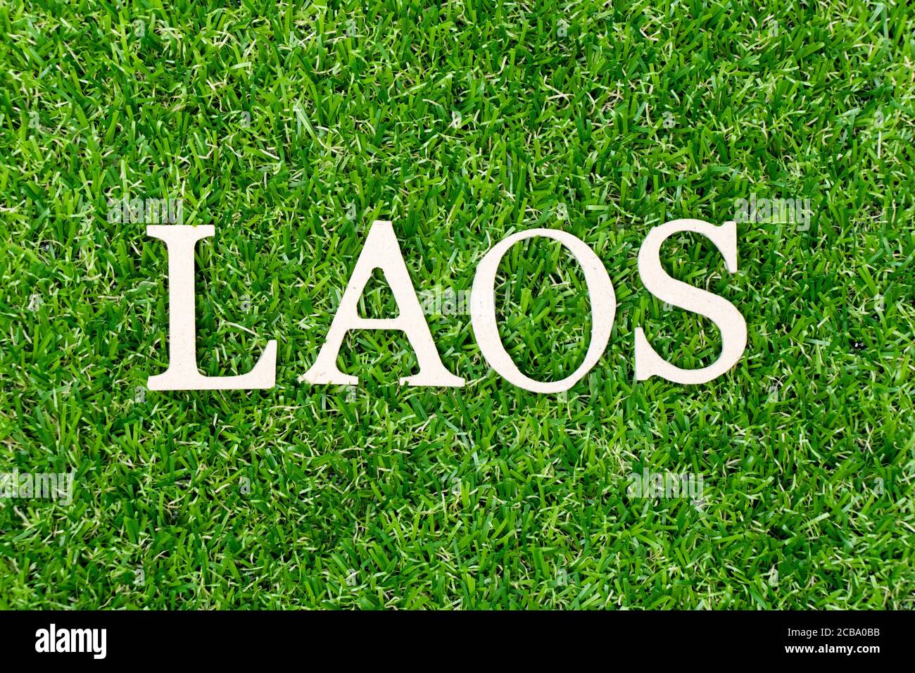 Wood letter in word Laos on green grass background Stock Photo - Alamy