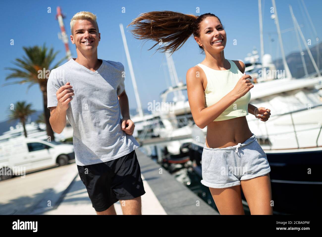 Happy fit people running and jogging together in summer sunny nature ...