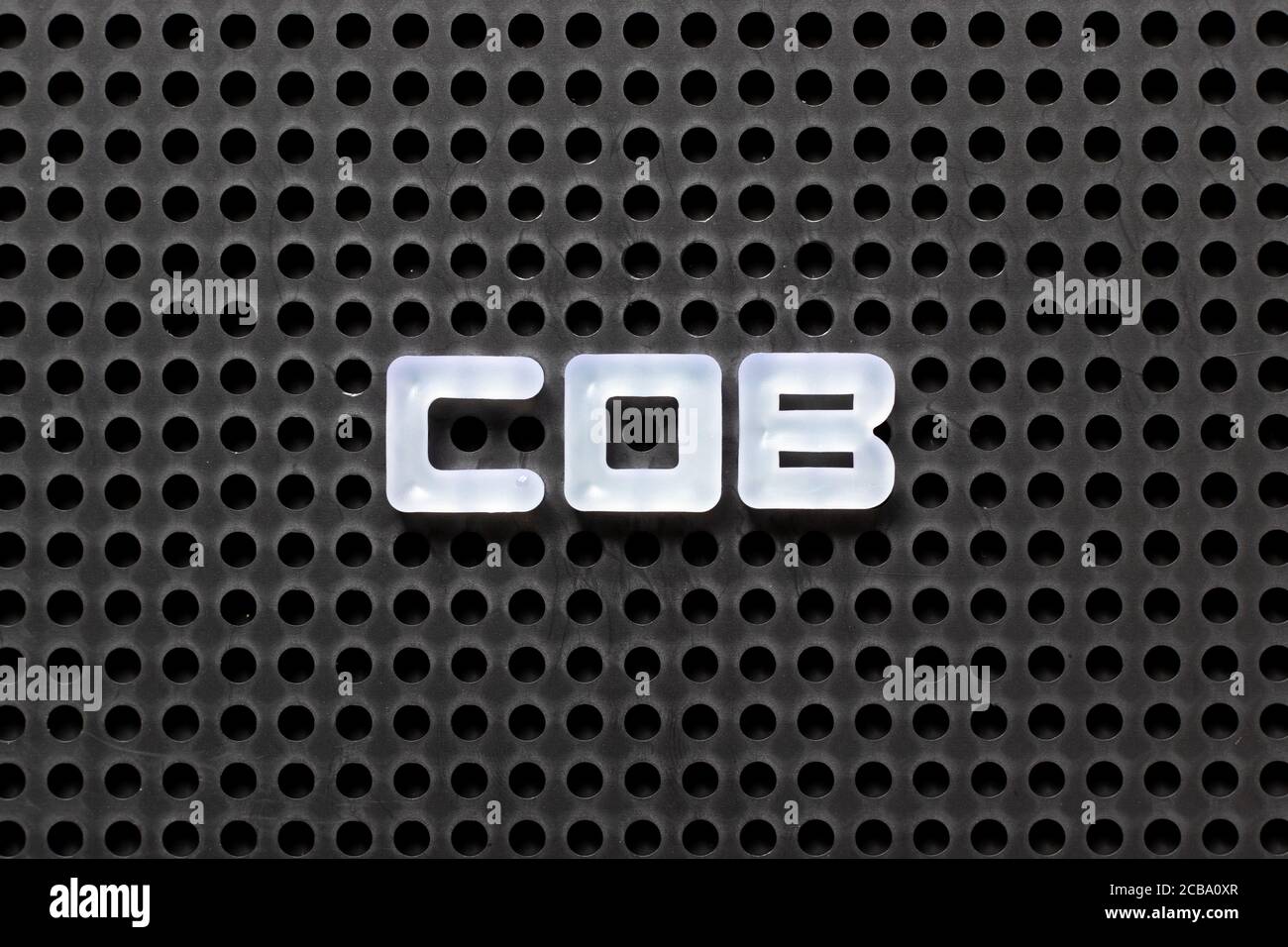 Black color pegboard with white letter in word COB (abbreviation of ...