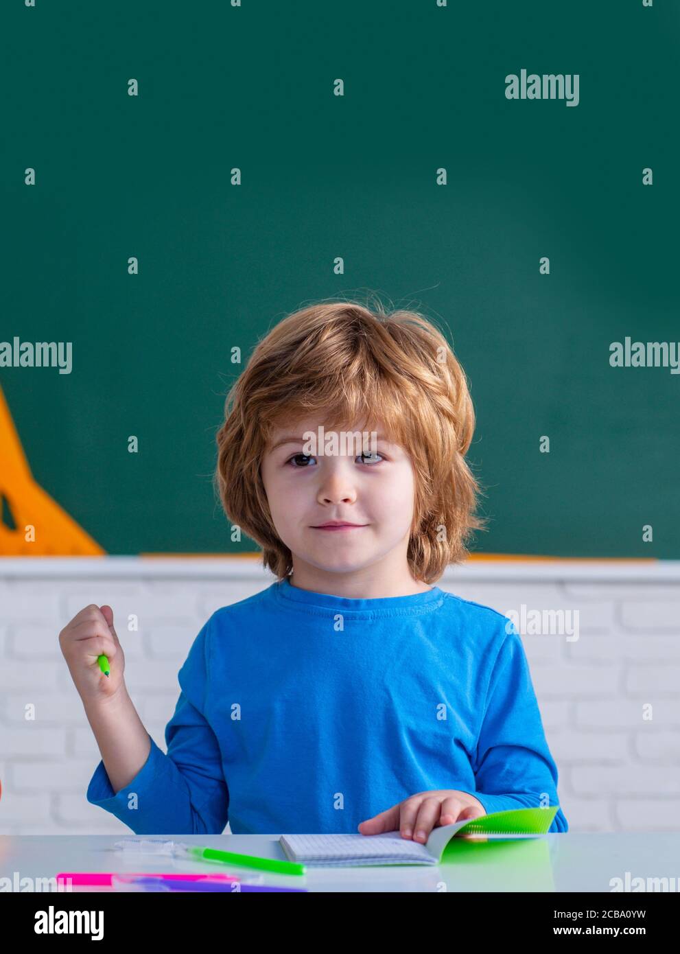 Children learning. Cute child boy in classroom near blackboard desk ...
