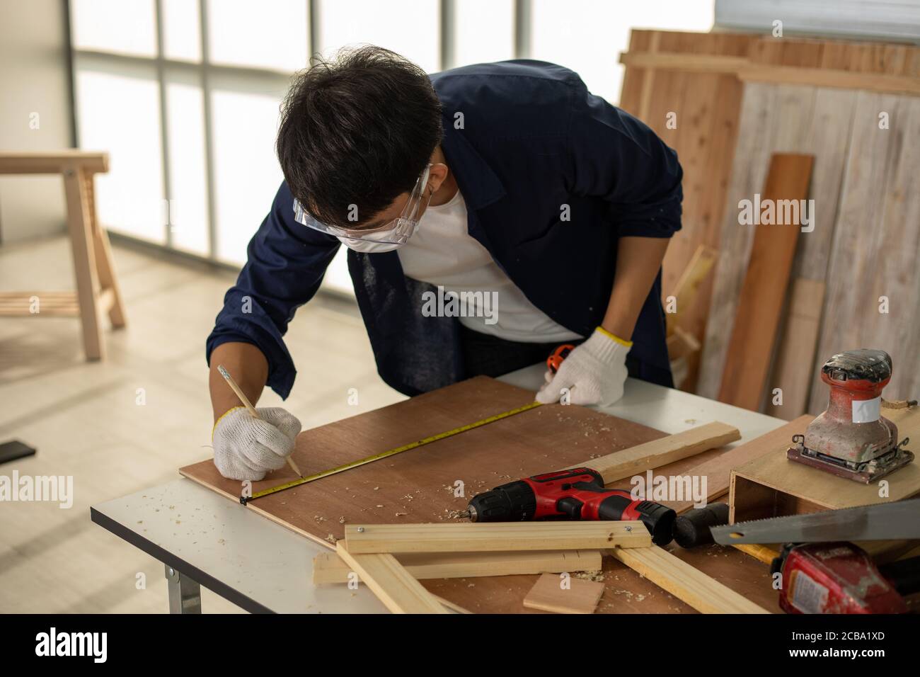 Asian man Carpenter working with technical drawing or blueprint ...