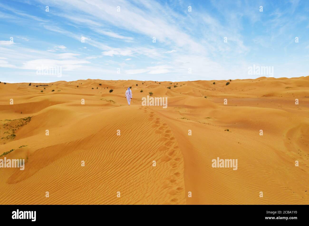 Arabian man walking at desert. Dressed in traditional Arabic suit Stock ...
