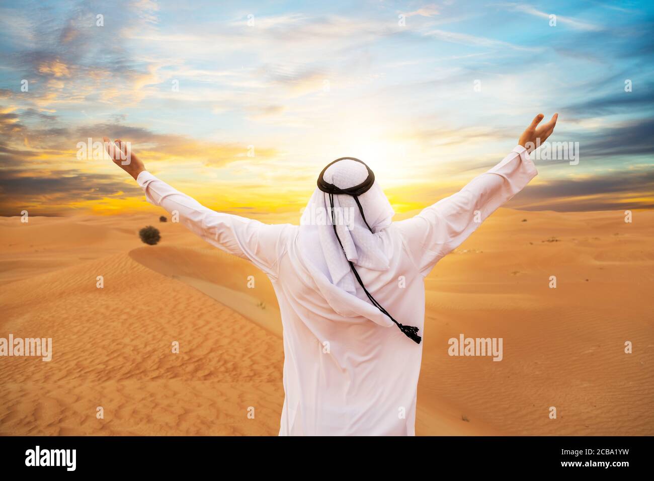Backview of Arabian man with raised hands in festive gesture. Dressed ...