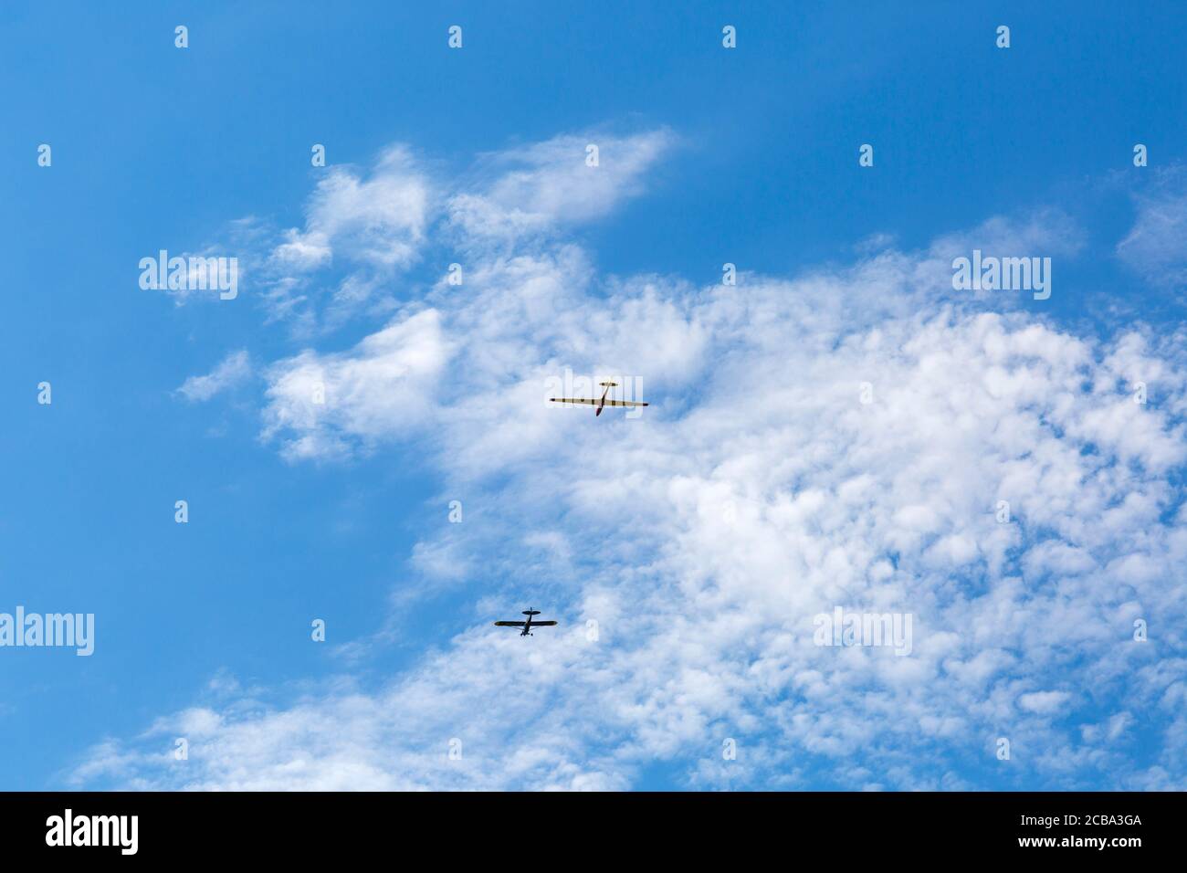 Tow plane towing glider during aerotow in sky at Bovington, Dorset UK ...