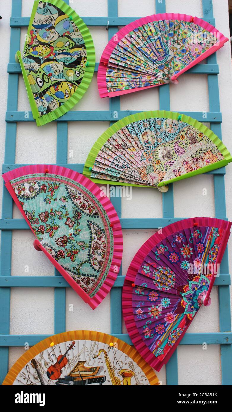 Colorful Spanish handmade fans attached to a blue wooden construction ...