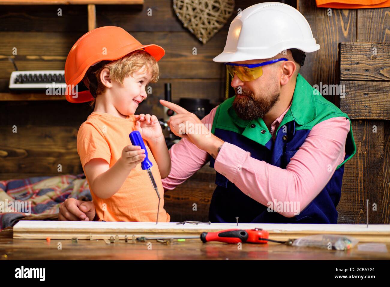 Tools construction. Father teaching little son to use carpenter tools ...