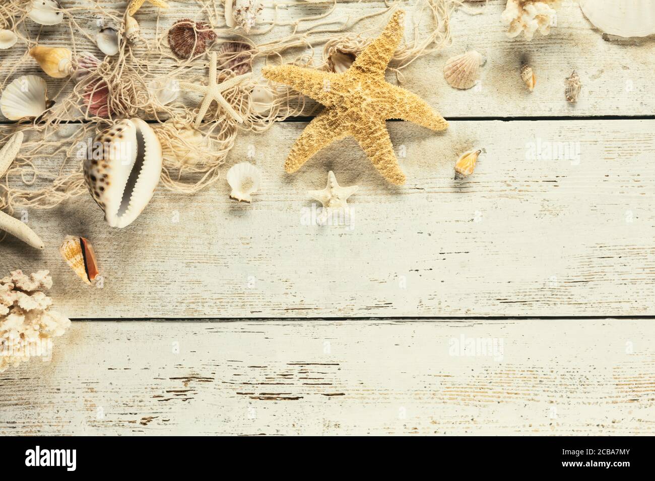 Seashells with fishing net placed on old wooden planks in vintage ...