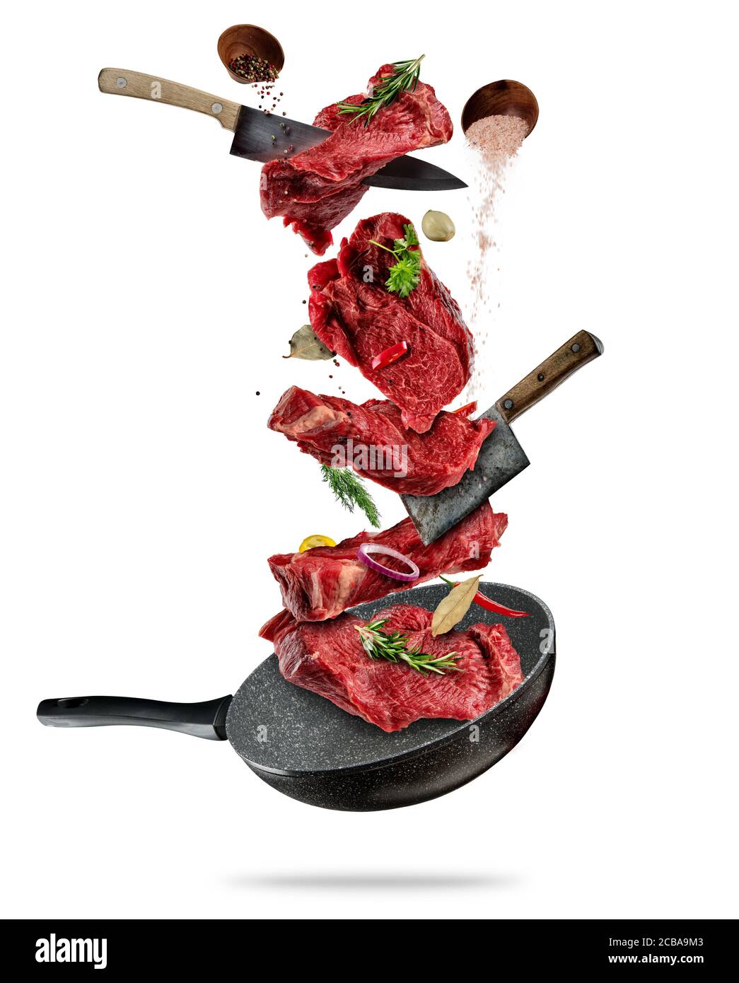Flying pieces of beef steaks from pan, isolated on white background ...