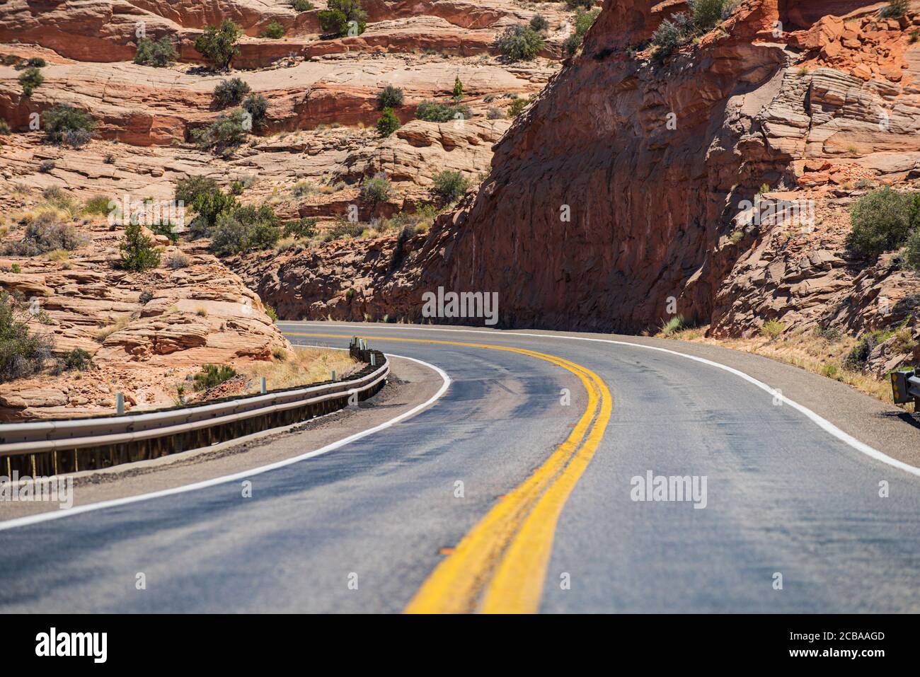 Landscape with orange rocks, sky with clouds and asphalt road in summer ...
