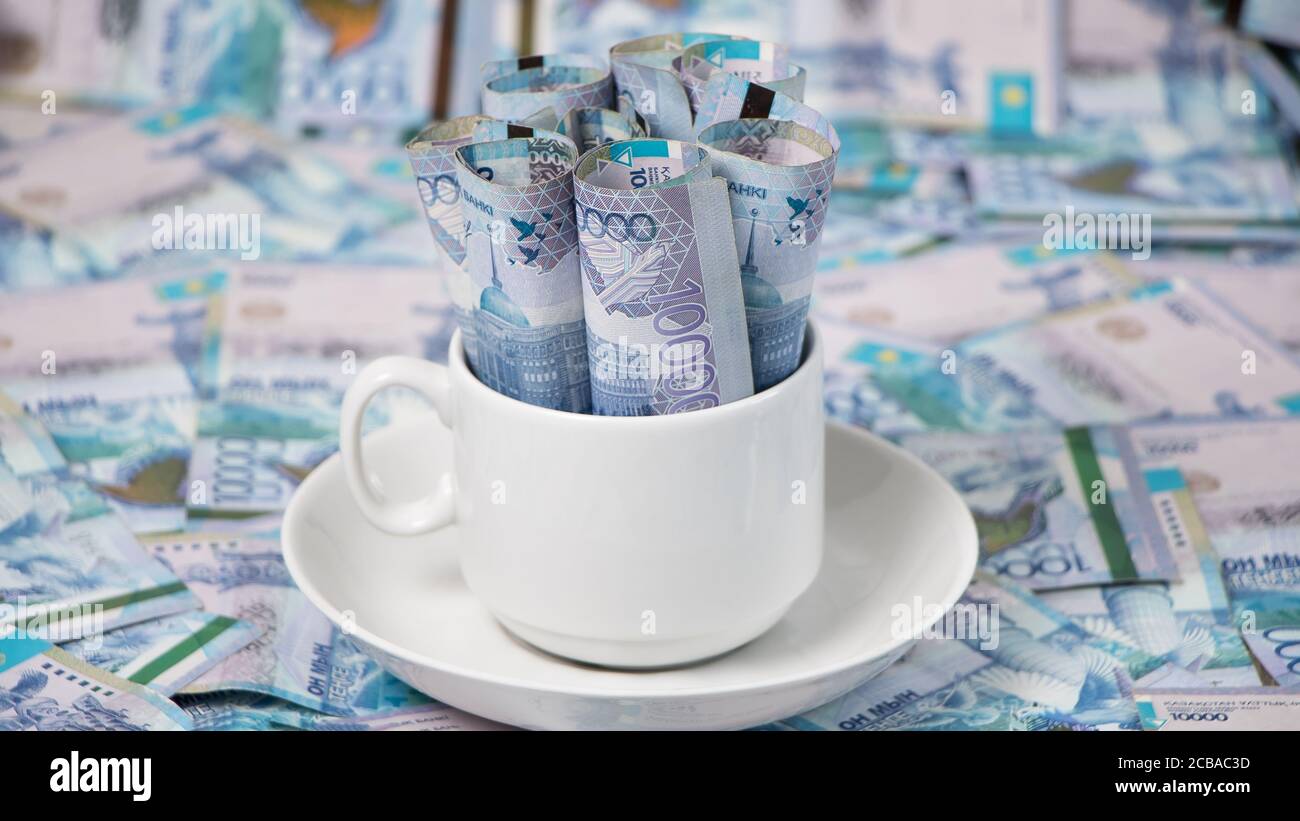 Kazakhstan tenge in a Cup on the table.A lot of Kazakh money.Sawing the ...
