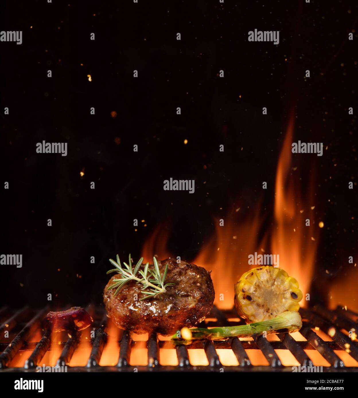 Piece of minced meal for hamburgers and vegetable placed on grill grid ...