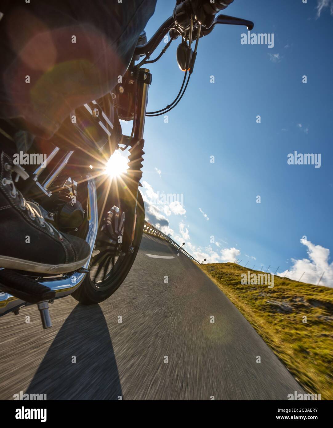 Motorcycle rider driving in Alps, beautiful nature with clear sky ...