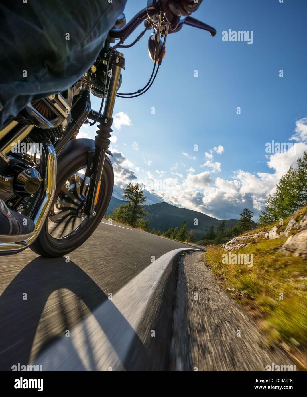 Motorcycle rider driving in Alps, beautiful nature with clear sky ...
