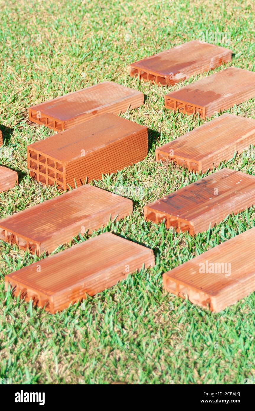 Bricks aligned over the grass Stock Photo - Alamy