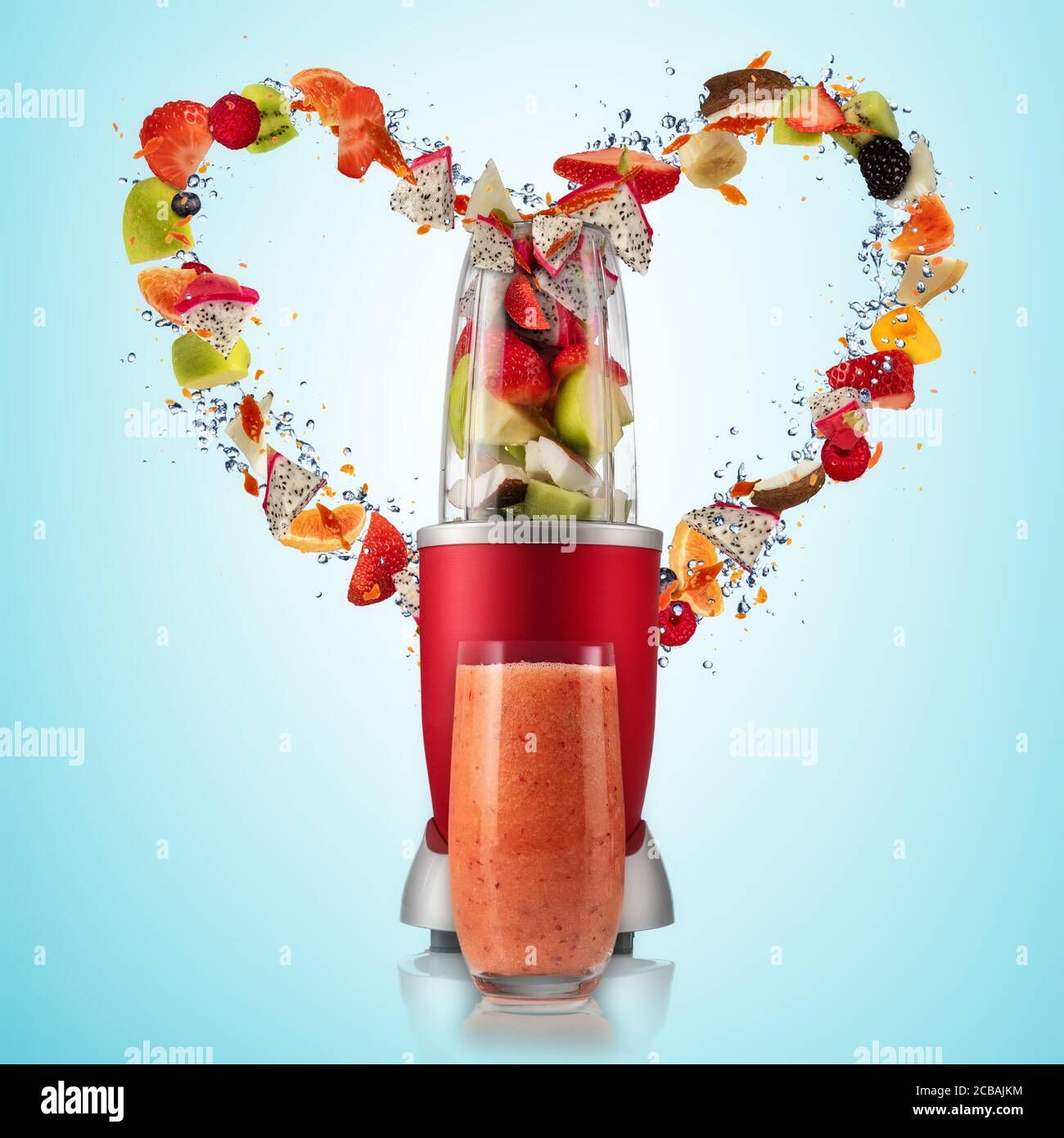 Smoothie mixer with drink and fruit flying ingredients in heart shape ...