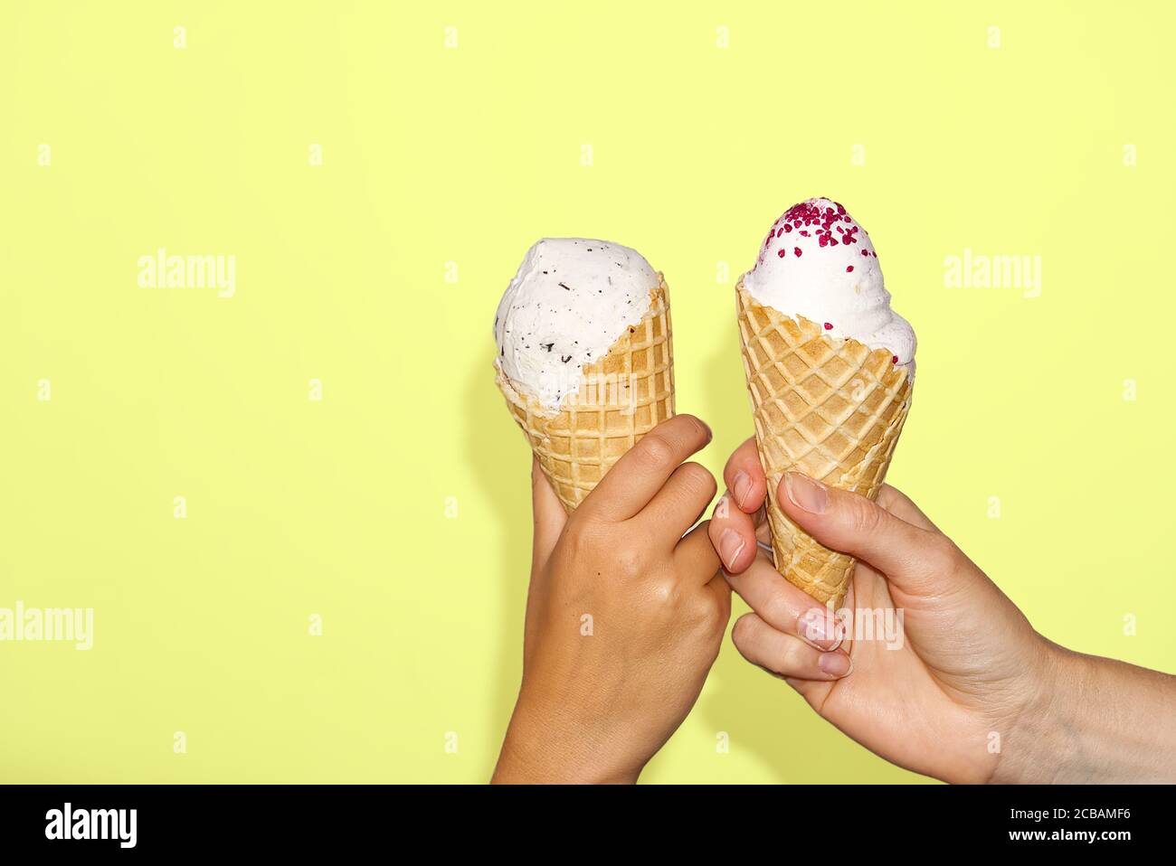 mother and daughter Hands holds ice cream corn with milk ice cream ...