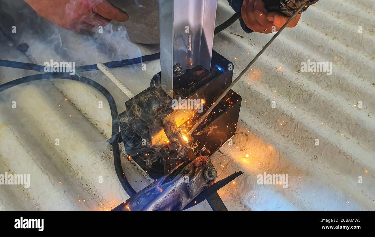 Welder welding an iron on top of a roof Stock Photo - Alamy