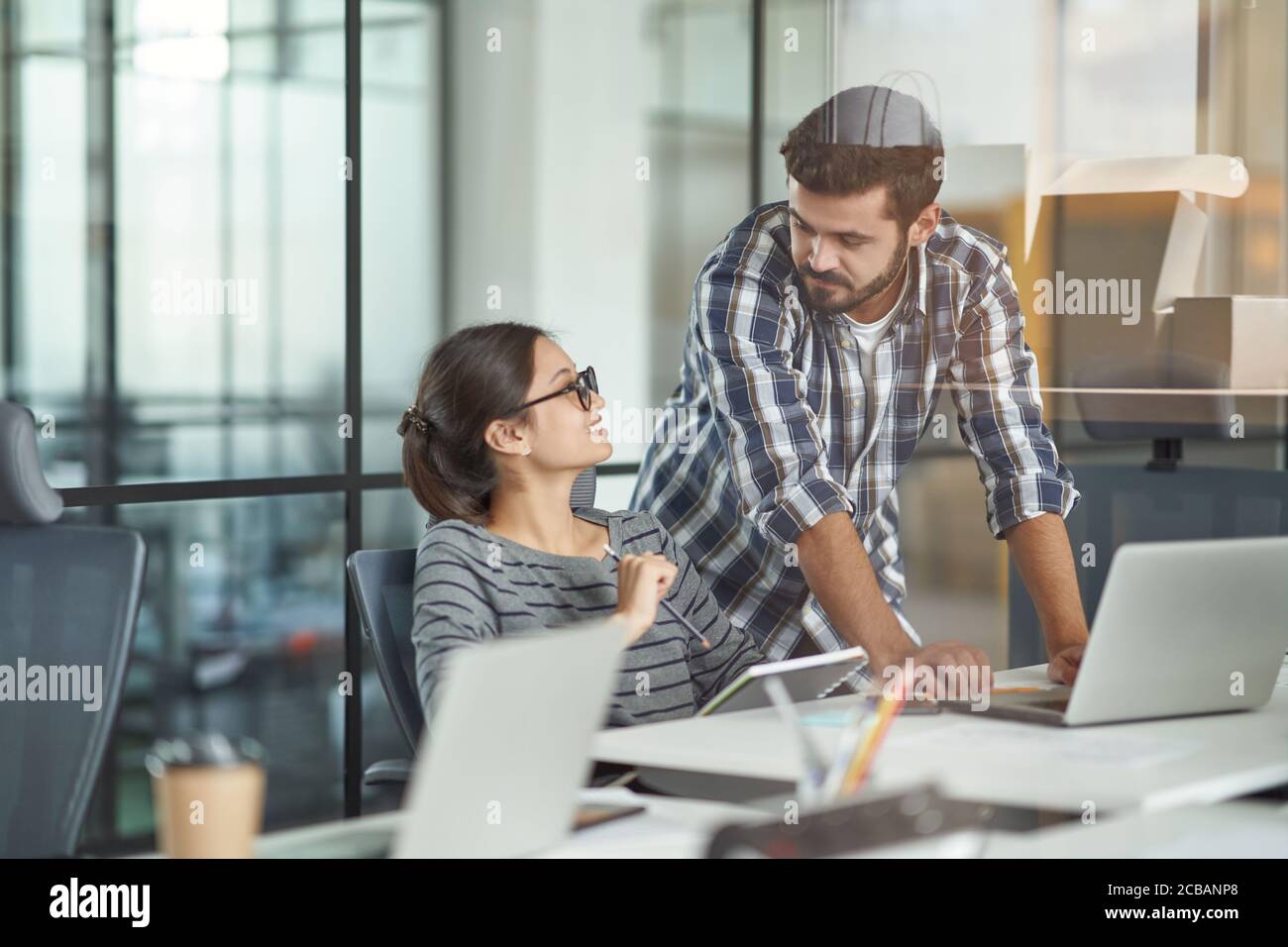 Having conversation at work. Young female and male colleagues talking ...