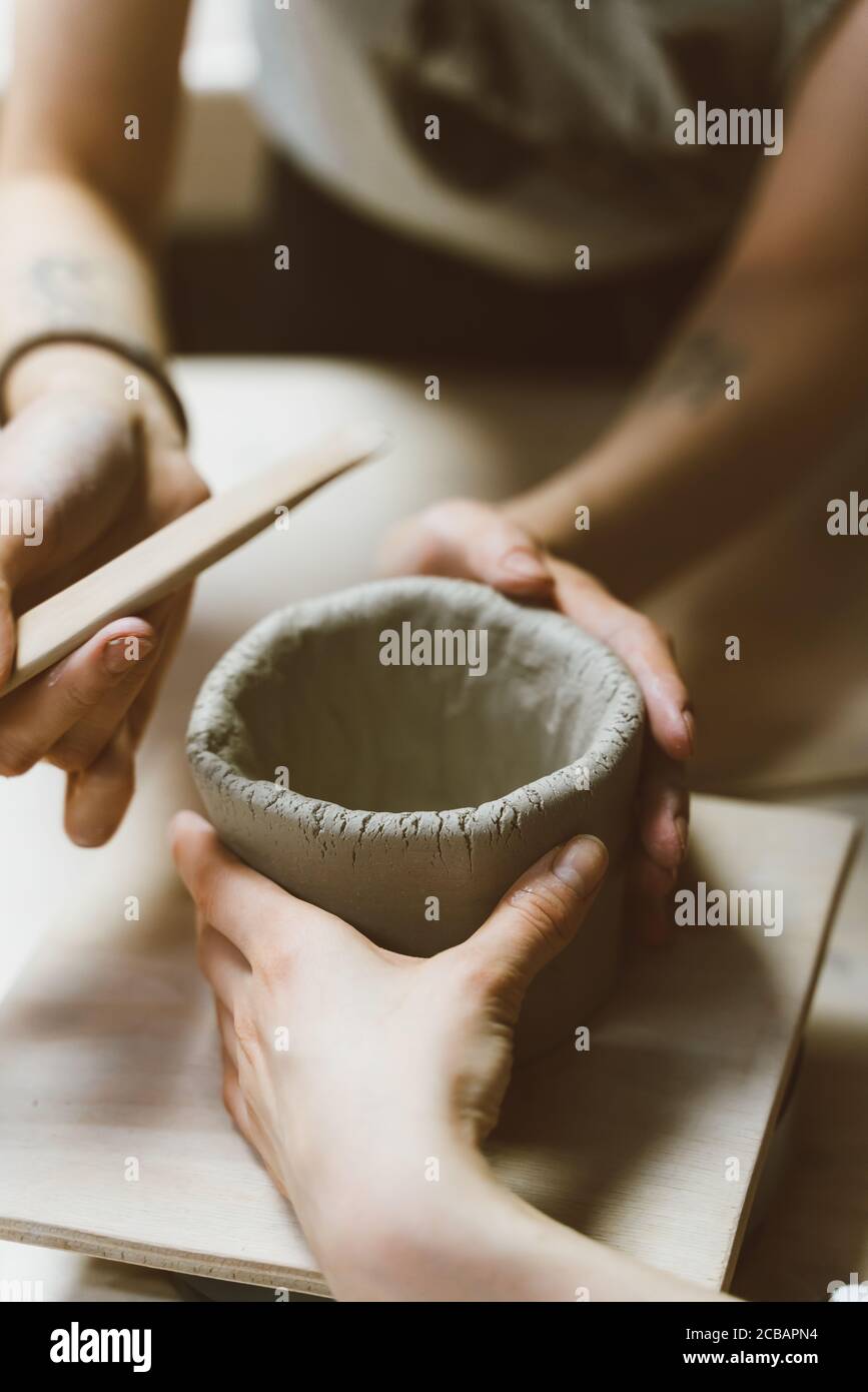 Woman making ceramic pottery, four hands close-up, focus on potters ...