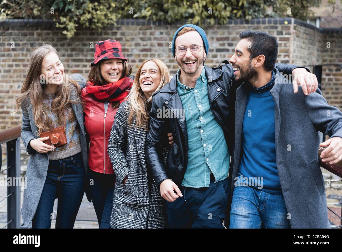 Group of millennial friends walking around city in winter time - Young ...