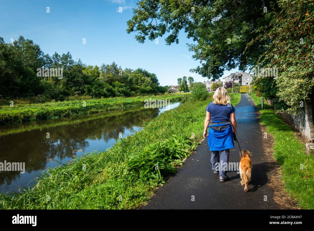 A dog walker on the path beside the River Ythan in the town of Ellon in ...