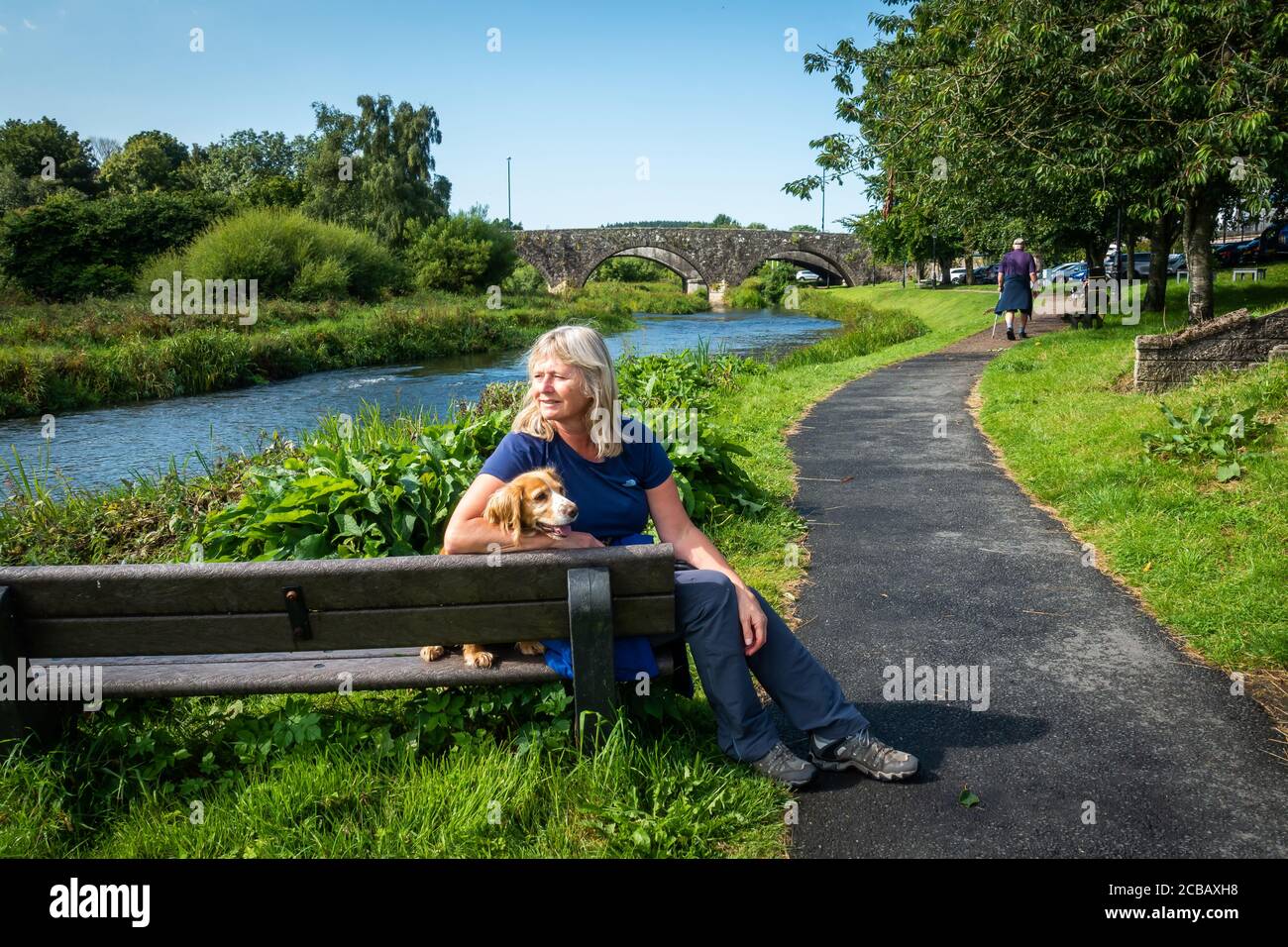 A dog walker on the path beside the River Ythan in the town of Ellon in ...