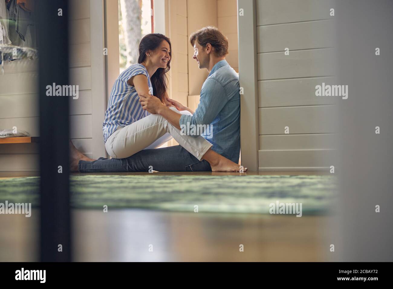 Smiling young people sitting opposite each other Stock Photo - Alamy