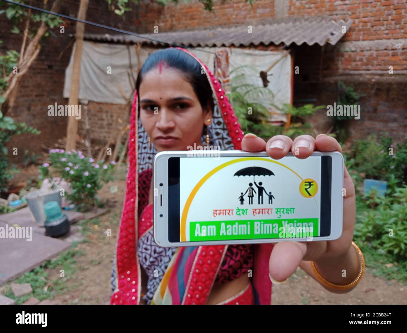 DISTRICT KATNI, INDIA - 28 MAY 2020: An indian lady holding smart phone ...