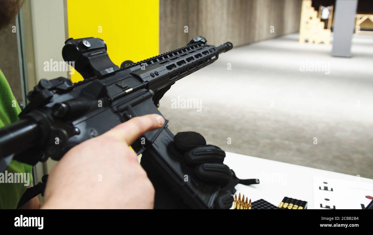 Adult loading an assault rifle at a shooting range Stock Photo - Alamy