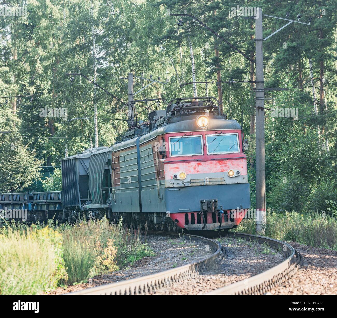 Freight train moves by the forest at summer day time Stock Photo - Alamy
