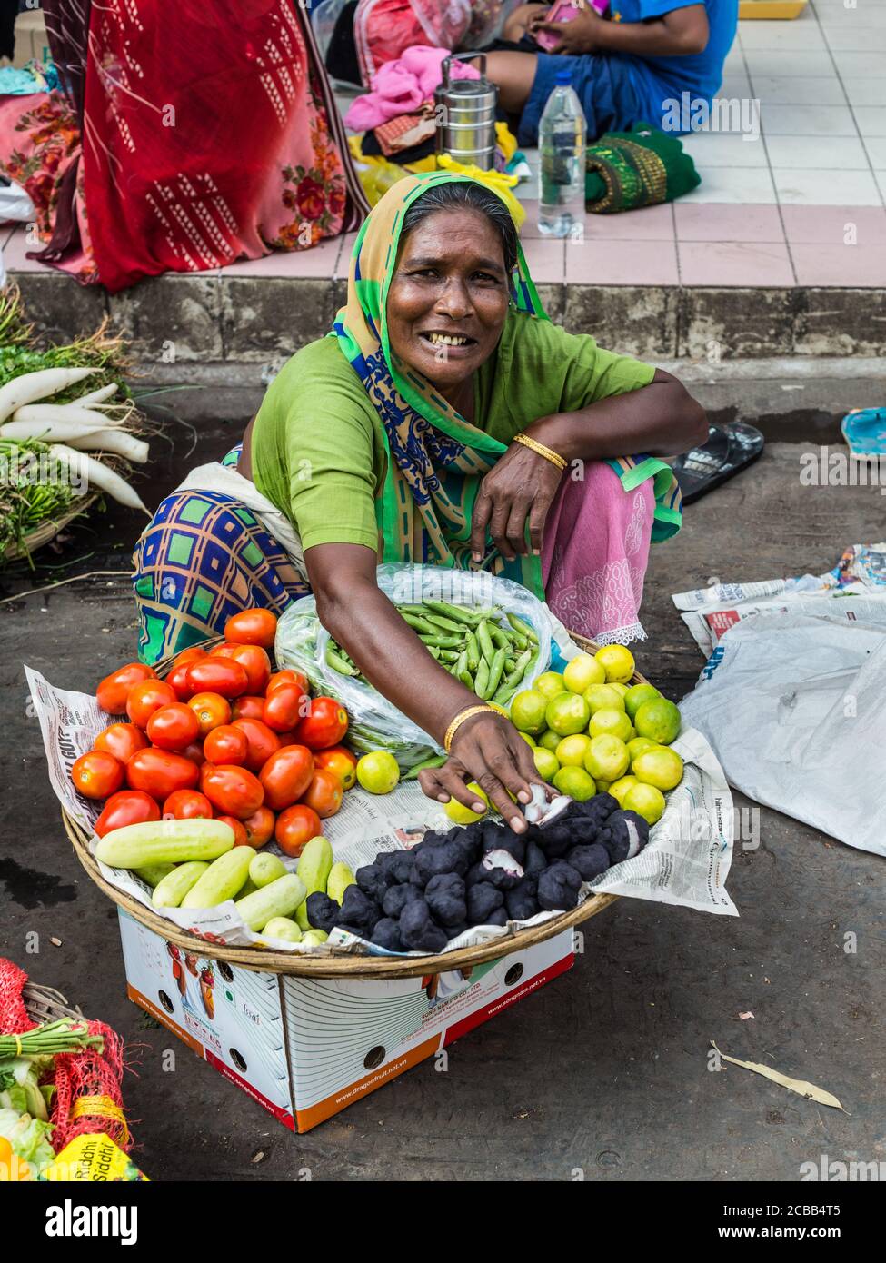 Mumbai, India - November 22, 2019: Indian woman selling fruits and vegetables at a street market ...