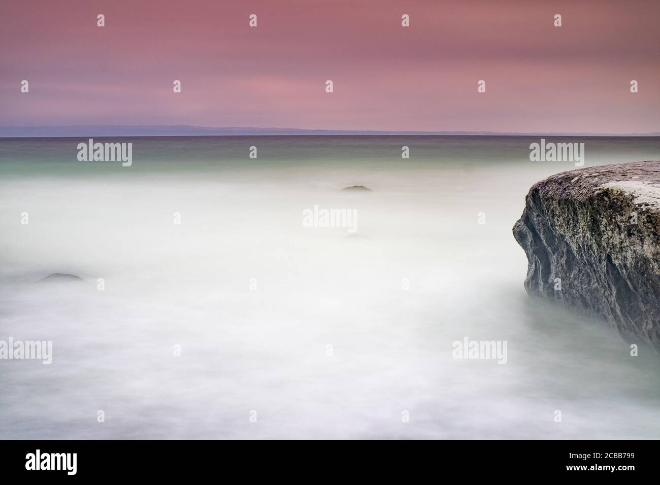 Long exposure sunset photo at Baltic sea beach. Smooth water level done ...