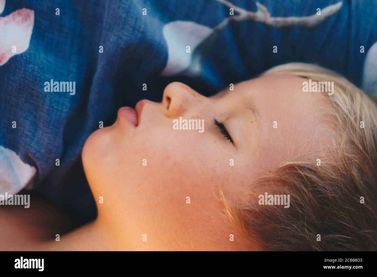 Cute little boy sleep sweetly on pillow with bright morning sunbeams ...