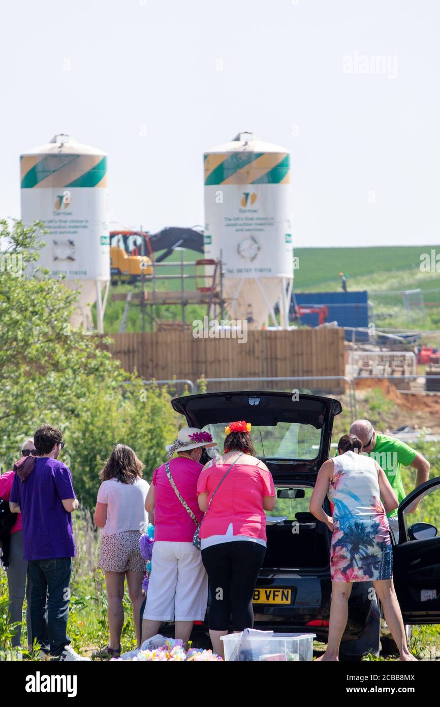 People getting ready for a parade with the concrete silos of a building ...
