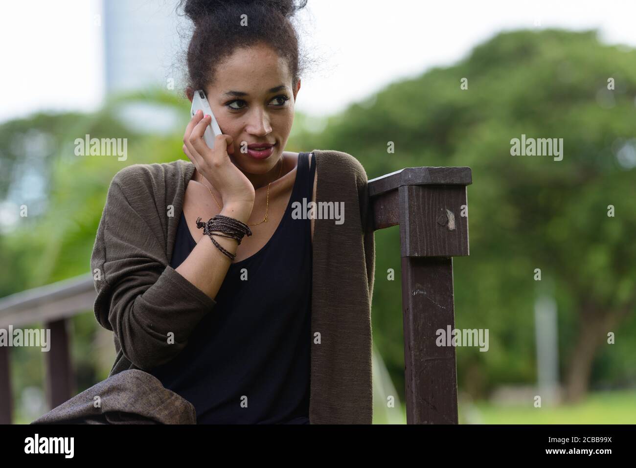 Portrait of young beautiful African woman talking on the phone at the ...