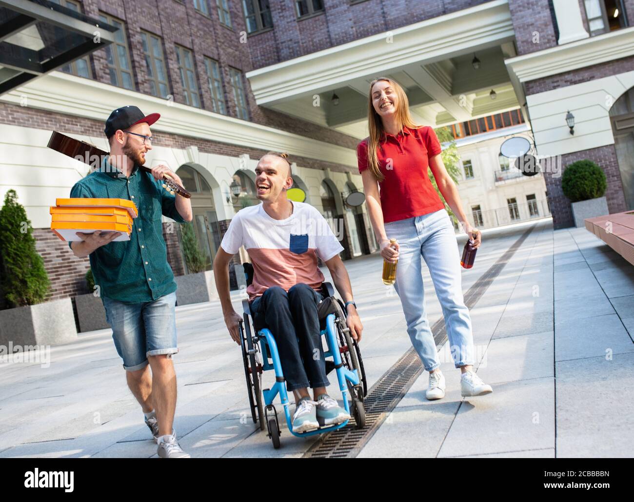 Group of friends taking a stroll on city's street in summer day ...