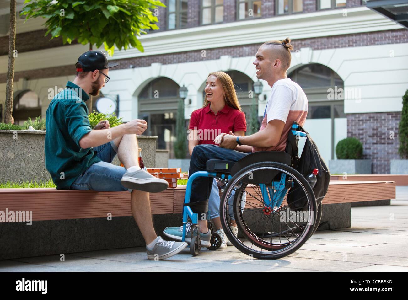 Group of friends taking a stroll on city's street in summer day ...