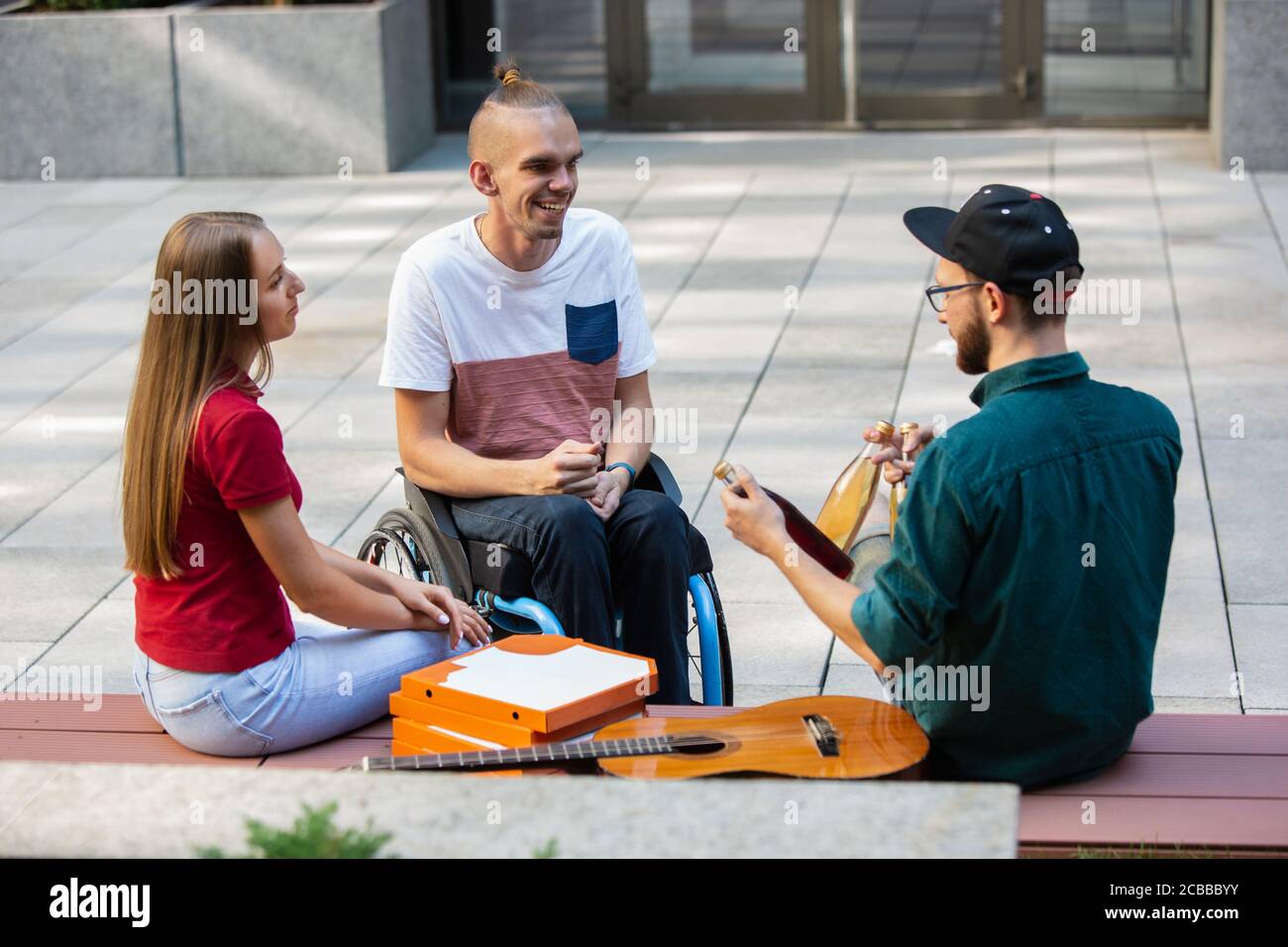 Group of friends taking a stroll on city's street in summer day ...