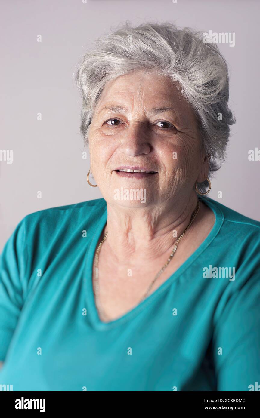 Senior woman smiling in studio portrait Stock Photo - Alamy