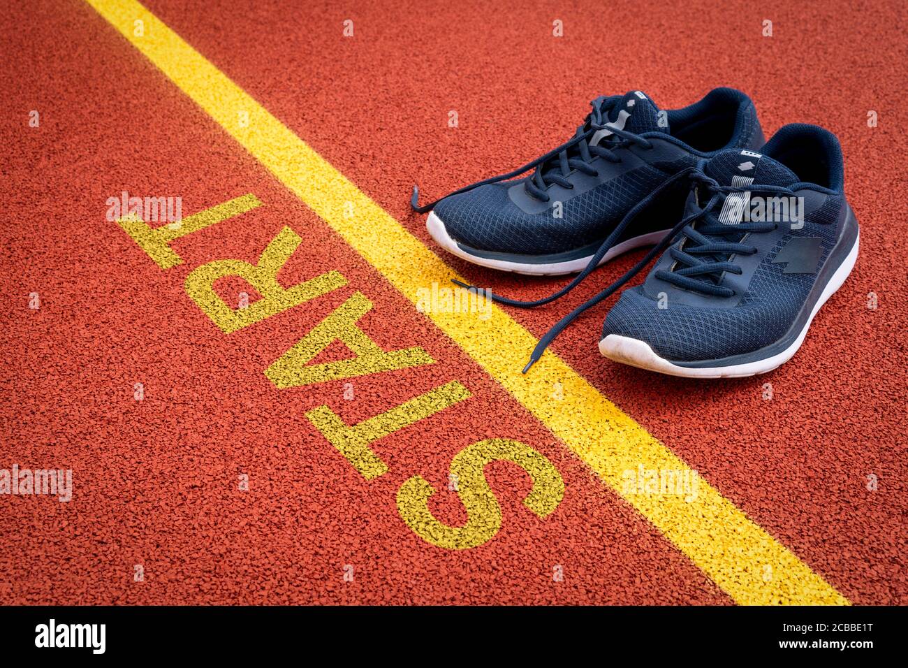 Running shoes are placed beside the start line on race track Stock ...