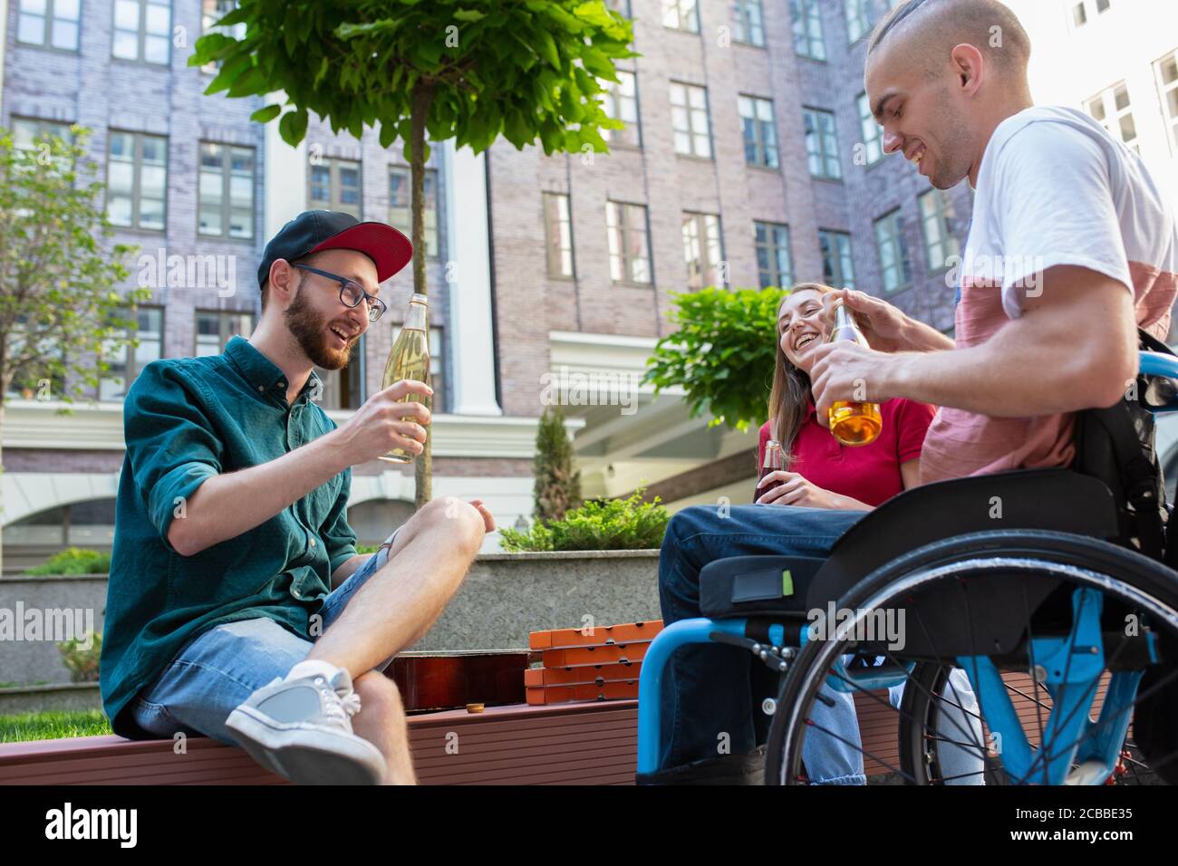 Beer time. Group of friends taking a stroll on city's street in summer ...