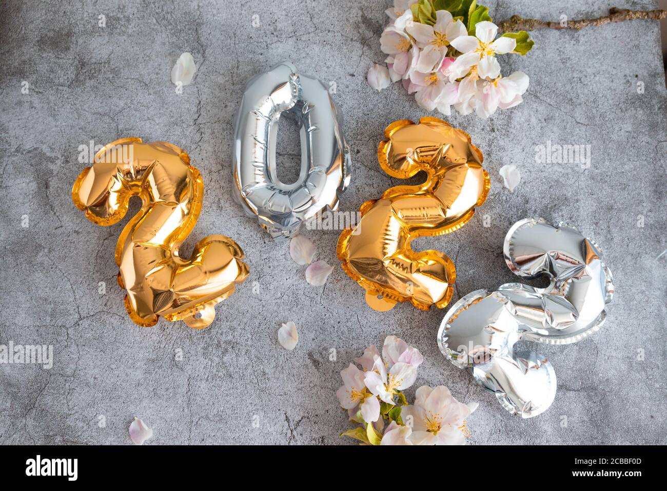 Gold and silver 2022 balloons numbers with apple tree branches on a ...