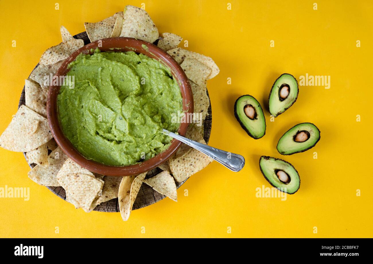 Top view of Mexican delicious nachos with guacamole and avocados on a ...