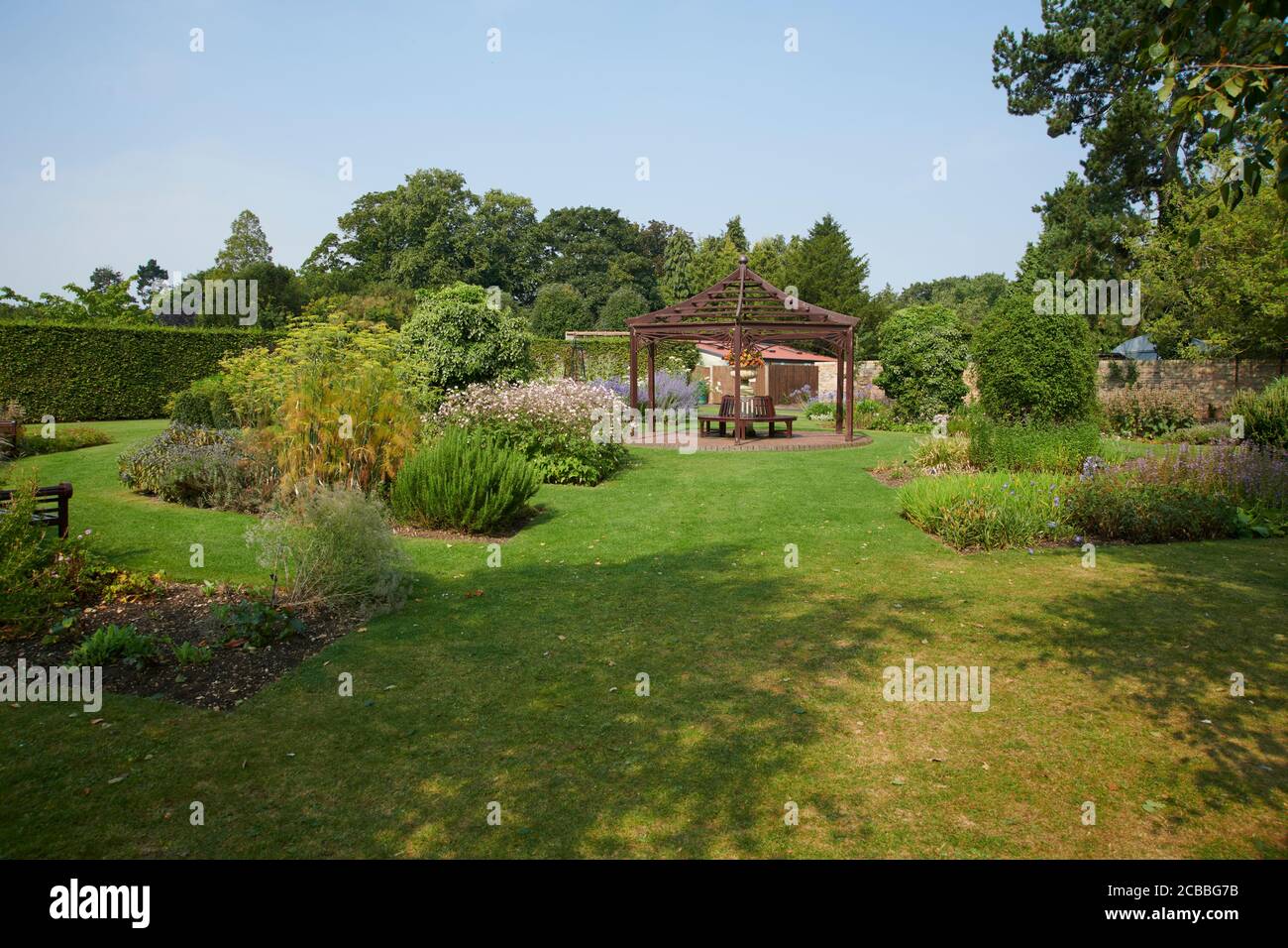 Wooden pergola and flower borders during the summer, in an English ...