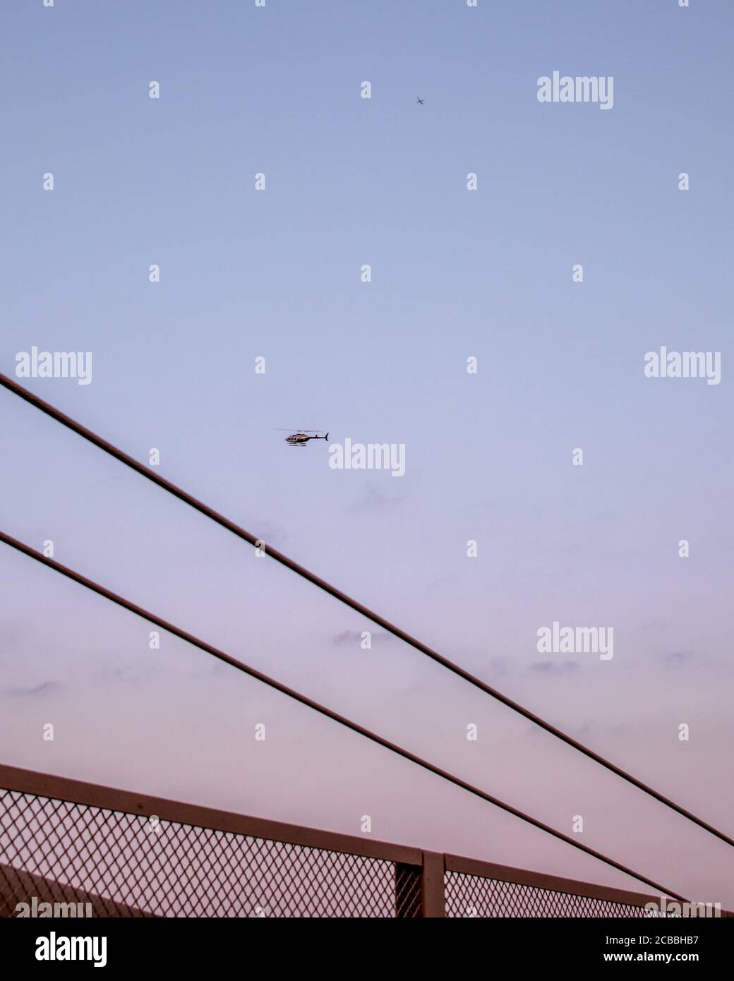 Low angle shot of a helicopter in a sunset seen through cables Stock ...