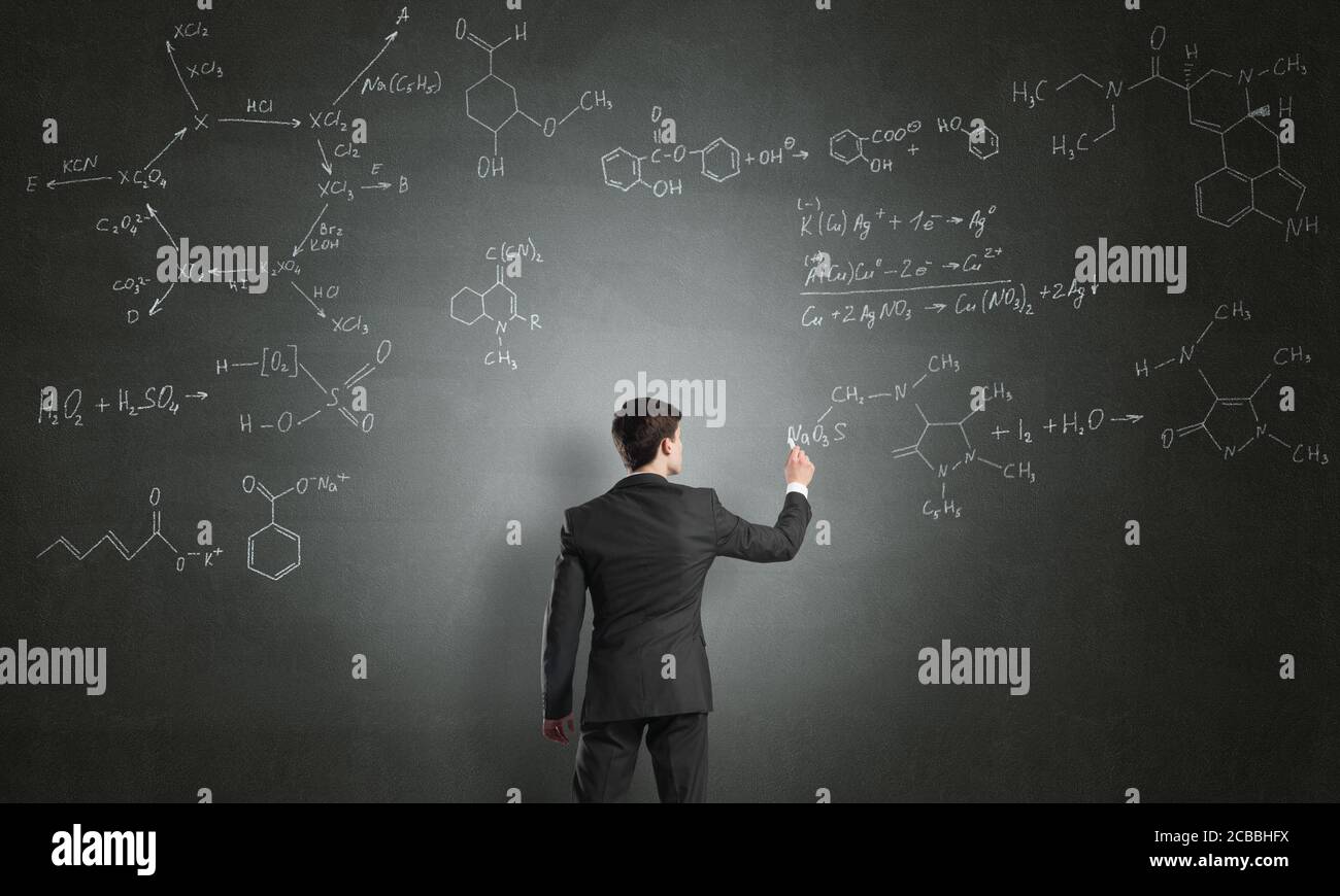 Scientist writing formulas on chalkboard Stock Photo - Alamy